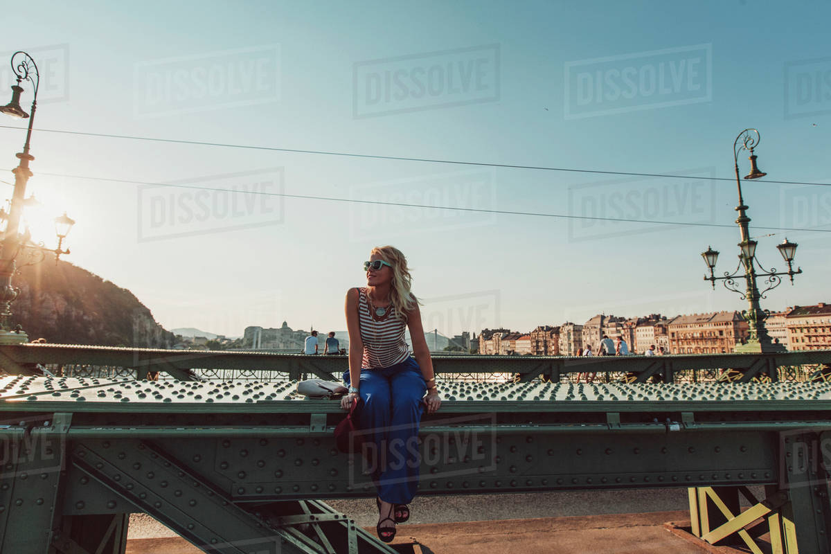 Caucasian woman sitting on bridge - Royalty-free Stock Photo | Dissolve