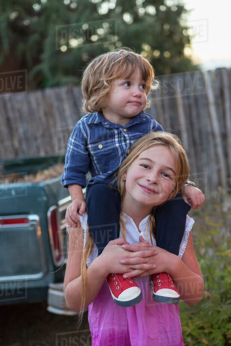 Caucasian girl carrying brother on shoulders - Royalty-free Stock Photo ...