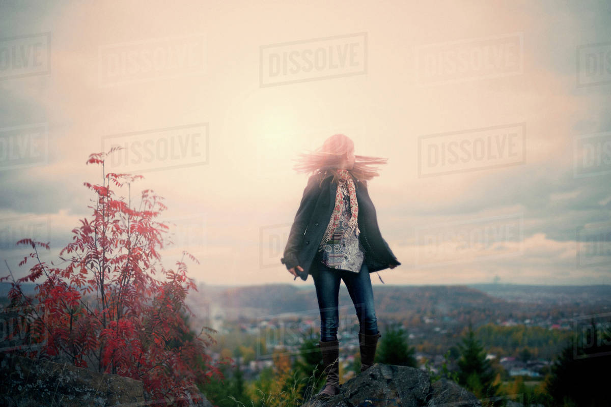 Caucasian girl standing on hilltop - Royalty-free Stock Photo | Dissolve