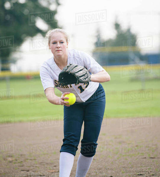 Caucasian softball player pitching ball in field - Stock Photo - Dissolve