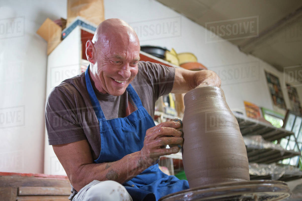 Older Caucasian man forming pottery on wheel in ceramics studio - Stock ...