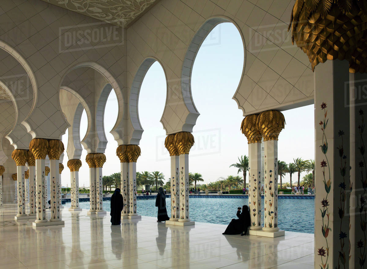 Women relaxing in colonnade near swimming pool - Stock Photo - Dissolve