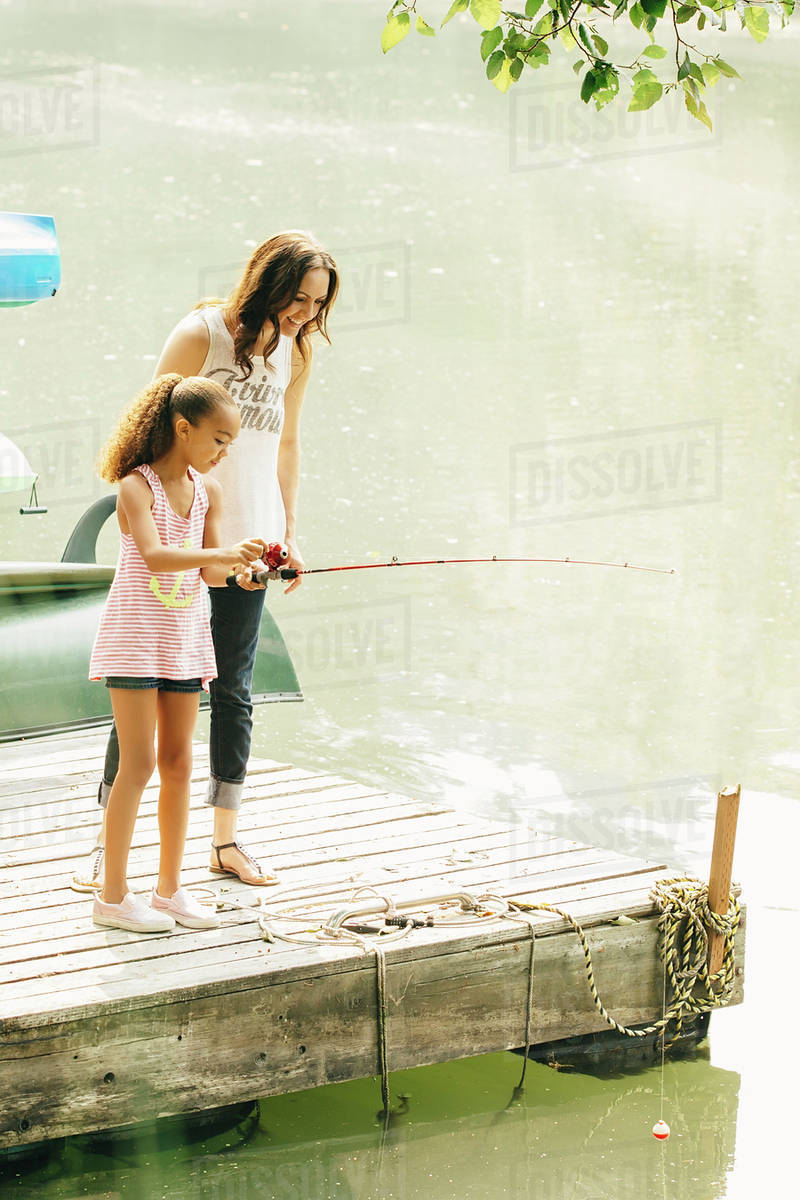 Mother and daughter fishing in lake - Royalty-free Stock Photo | Dissolve