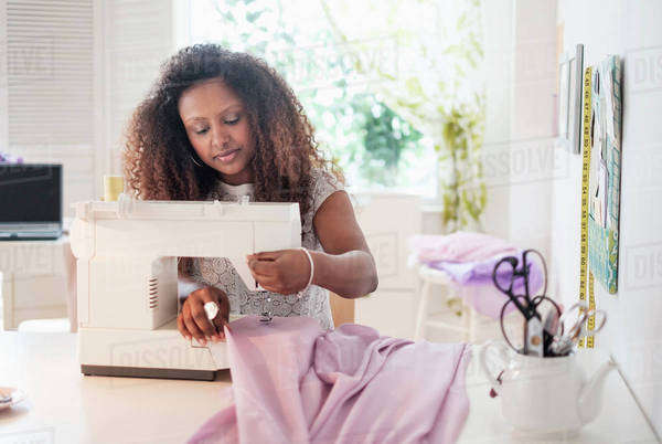 Black woman using sewing machine - Royalty-free Stock Photo | Dissolve