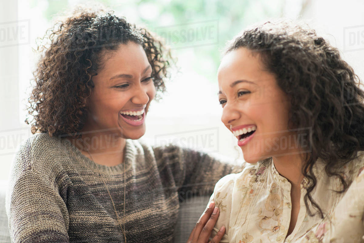 Laughing women relaxing on sofa - Stock Photo - Dissolve