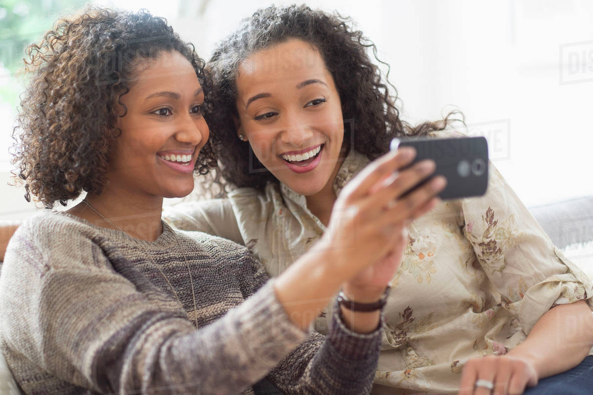 Smiling women taking cell phone photograph - Royalty-free Stock Photo ...