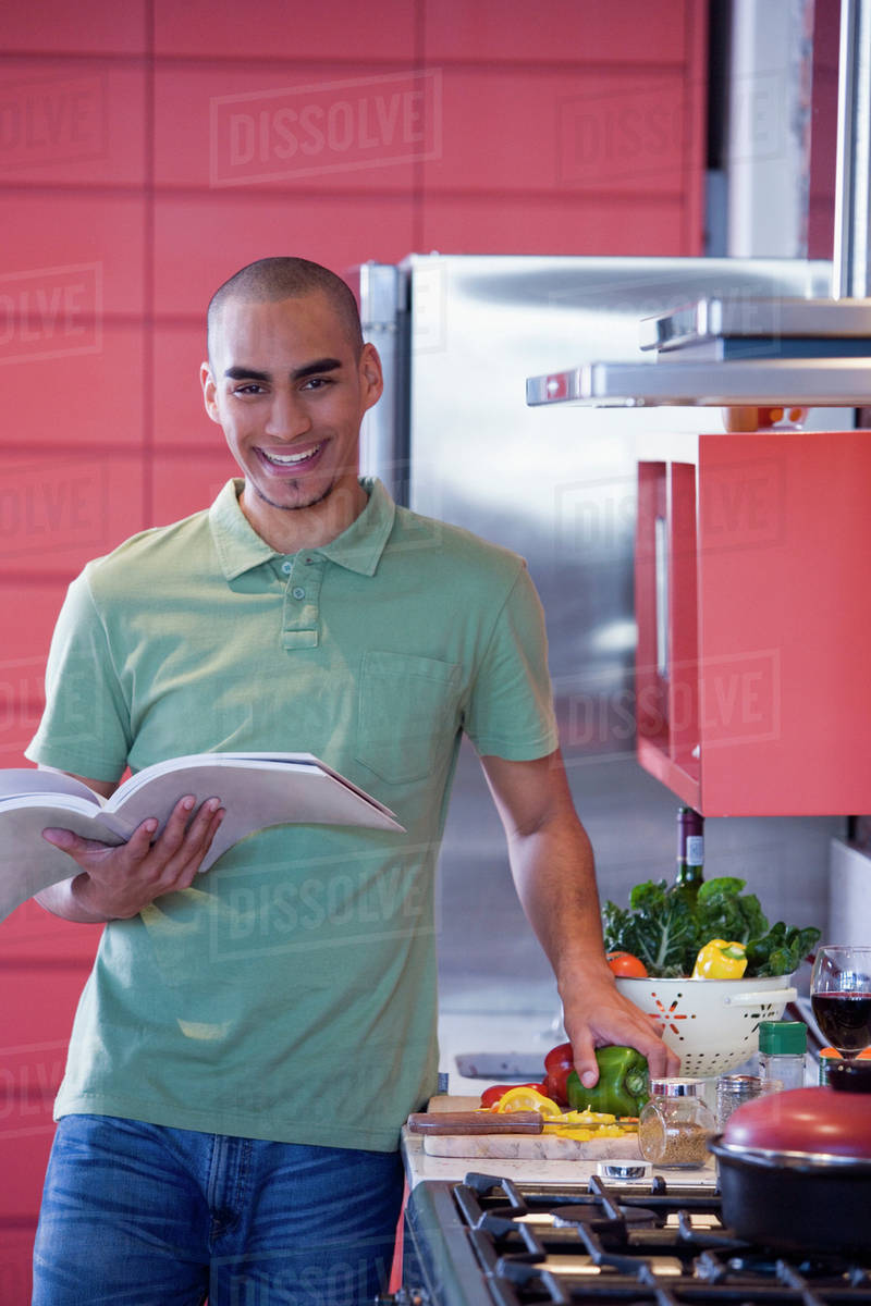 African American man reading cookbook - Royalty-free Stock Photo | Dissolve