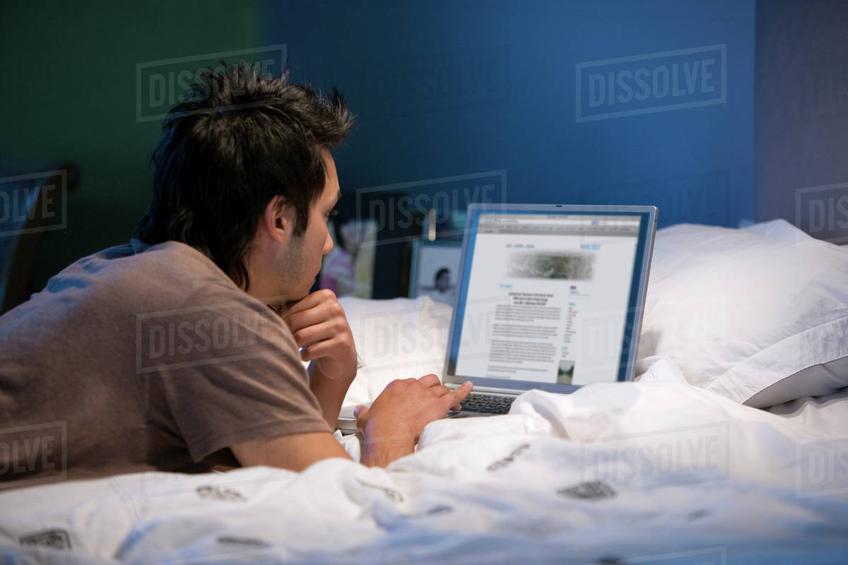 Asian man looking at laptop - Stock Photo - Dissolve