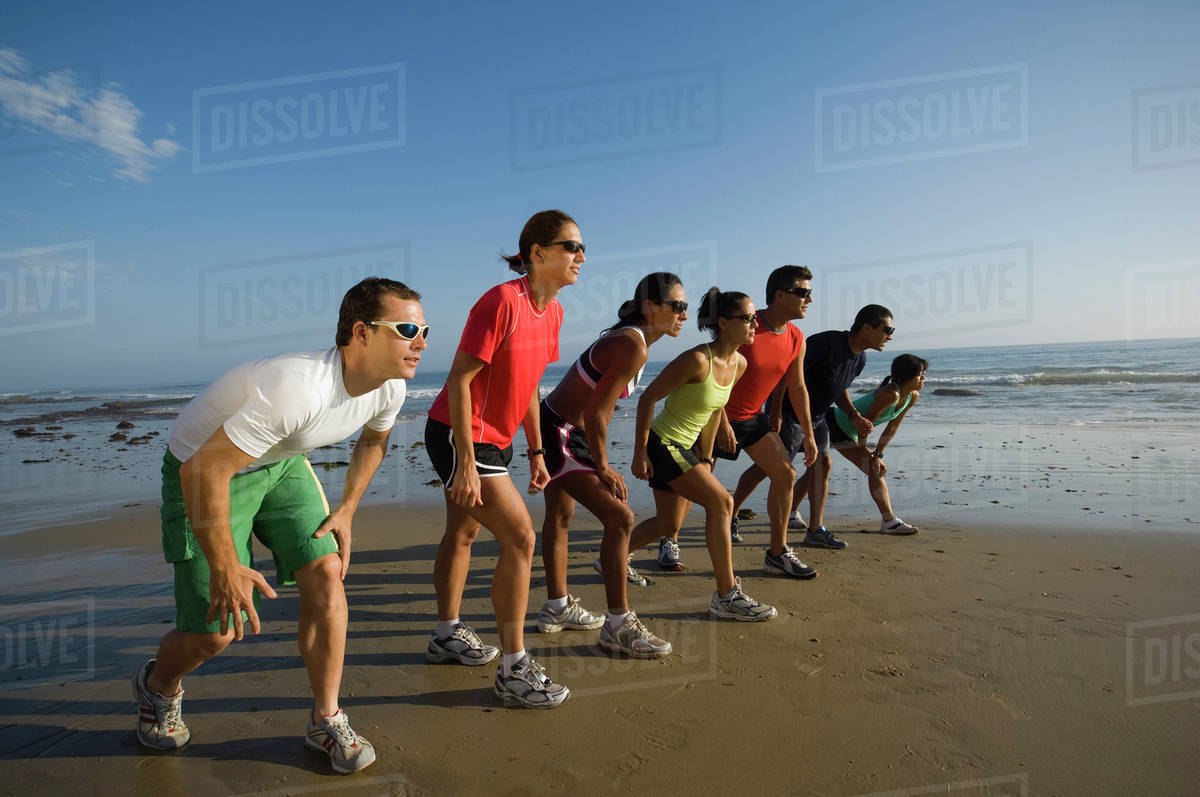 Multi-ethnic runners racing at beach - Stock Photo - Dissolve