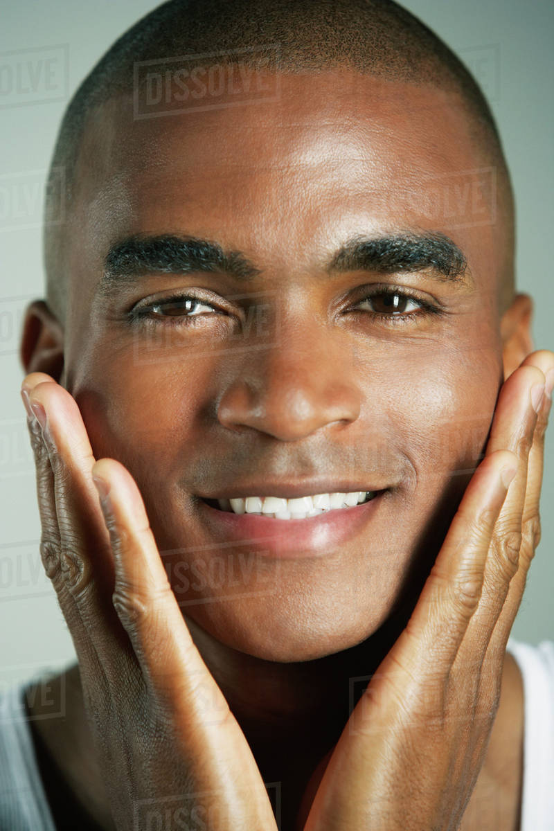 African man with hands on face - Royalty-free Stock Photo | Dissolve