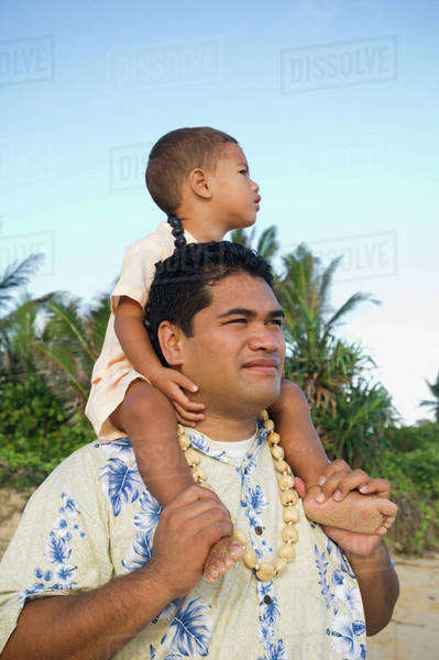 Pacific Islander father with son on shoulders at beach - Royalty-free ...