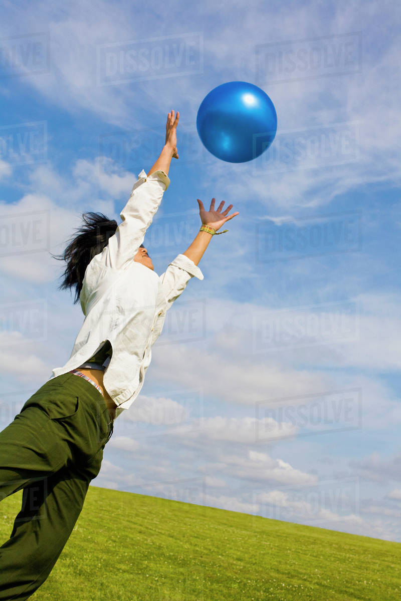 Asian man jumping for ball - Royalty-free Stock Photo | Dissolve