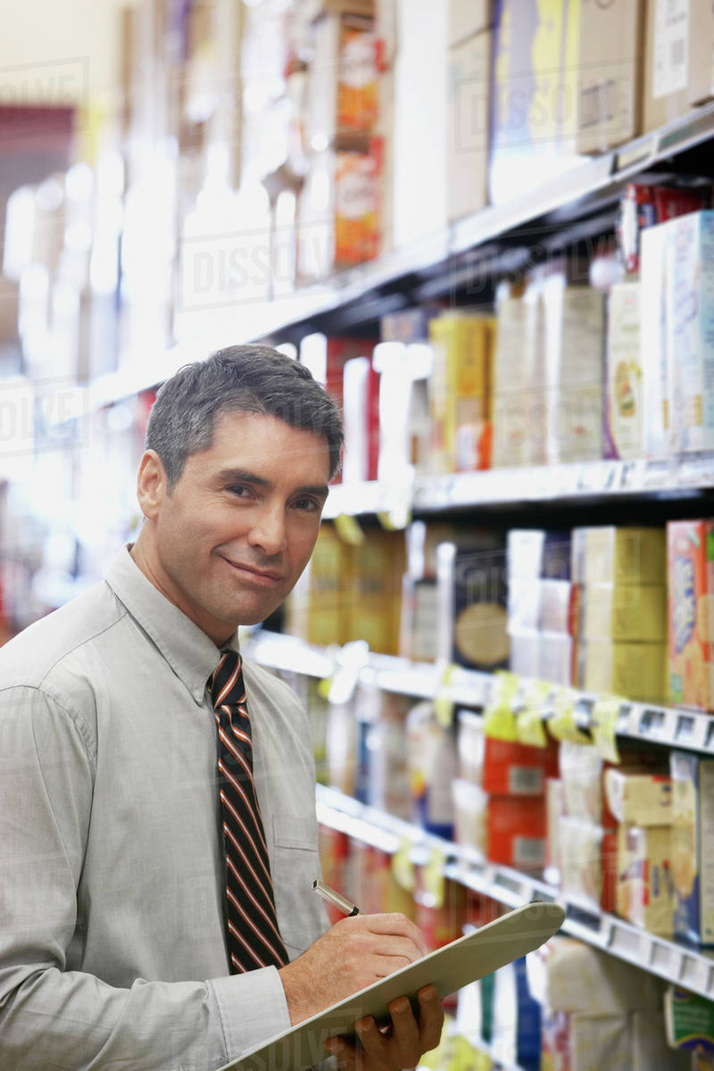 Hispanic grocery store manager holding clipboard - Royalty-free Stock ...