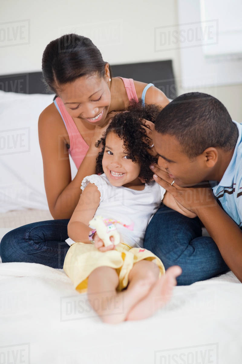 African parents smiling at daughter - Royalty-free Stock Photo | Dissolve