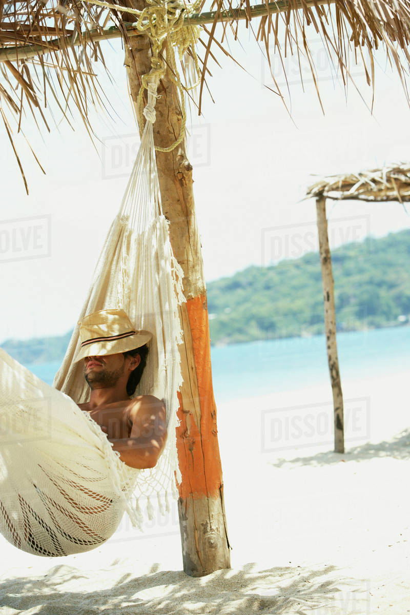 Hispanic man laying in hammock - Royalty-free Stock Photo | Dissolve
