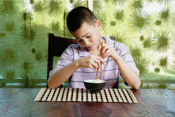 Asian boy eating bowl of rice - Royalty-free Stock Photo | Dissolve