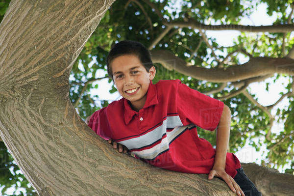 Hispanic boy climbing tree - Royalty-free Stock Photo | Dissolve