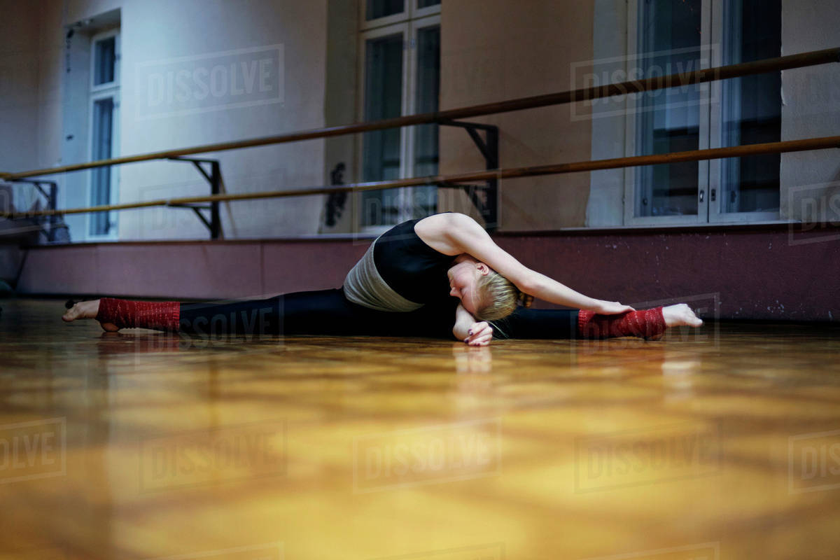 Caucasian dancer stretching doing splits on studio floor - Royalty-free ...