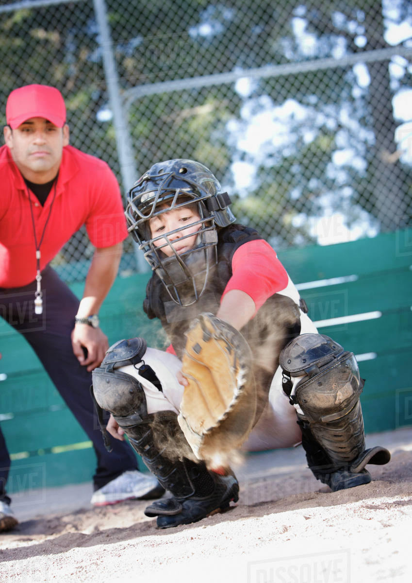 Multi-ethnic baseball catcher and coach behind home plate - Royalty ...