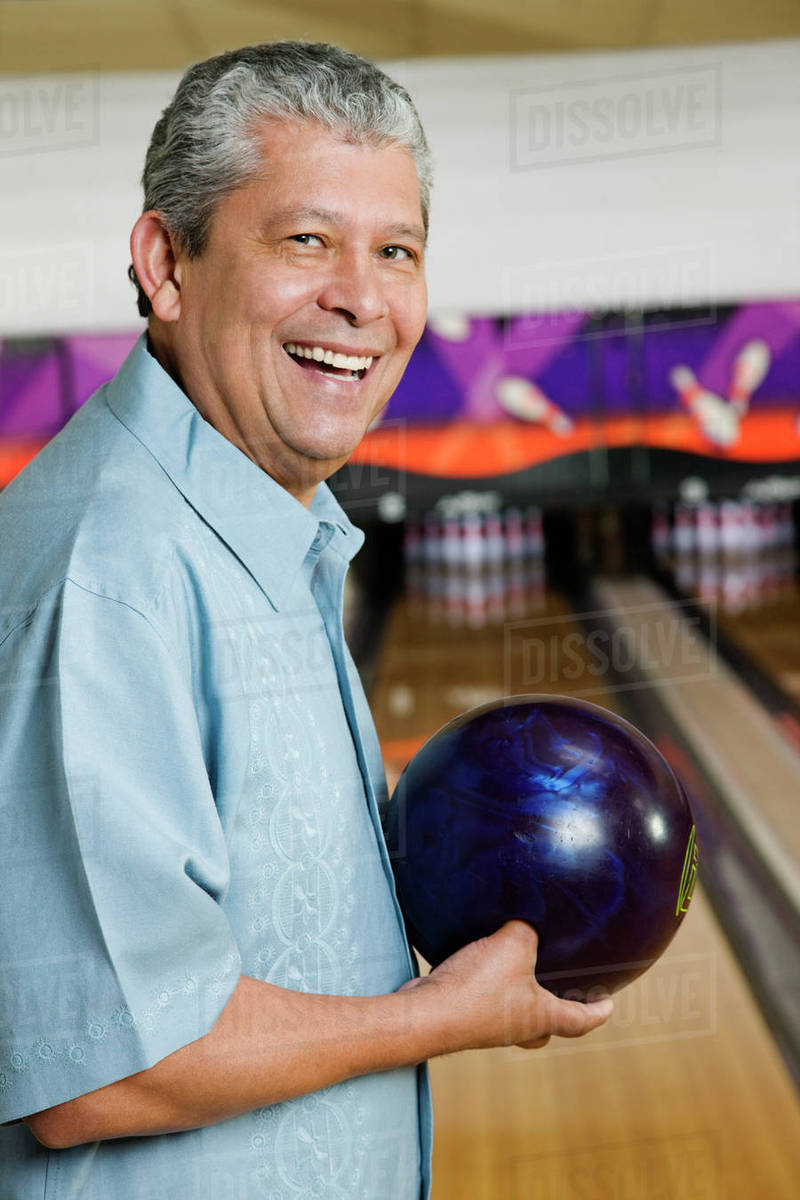 Hispanic man holding bowling ball - Royalty-free Stock Photo | Dissolve