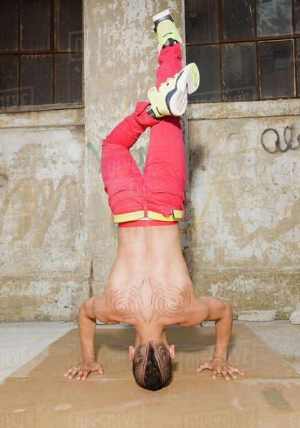 Hispanic teenage boy doing headstand - Royalty-free Stock Photo | Dissolve