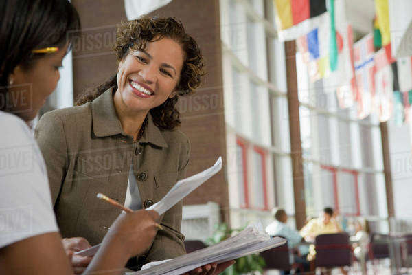 Teacher giving paperwork to student - Royalty-free Stock Photo | Dissolve