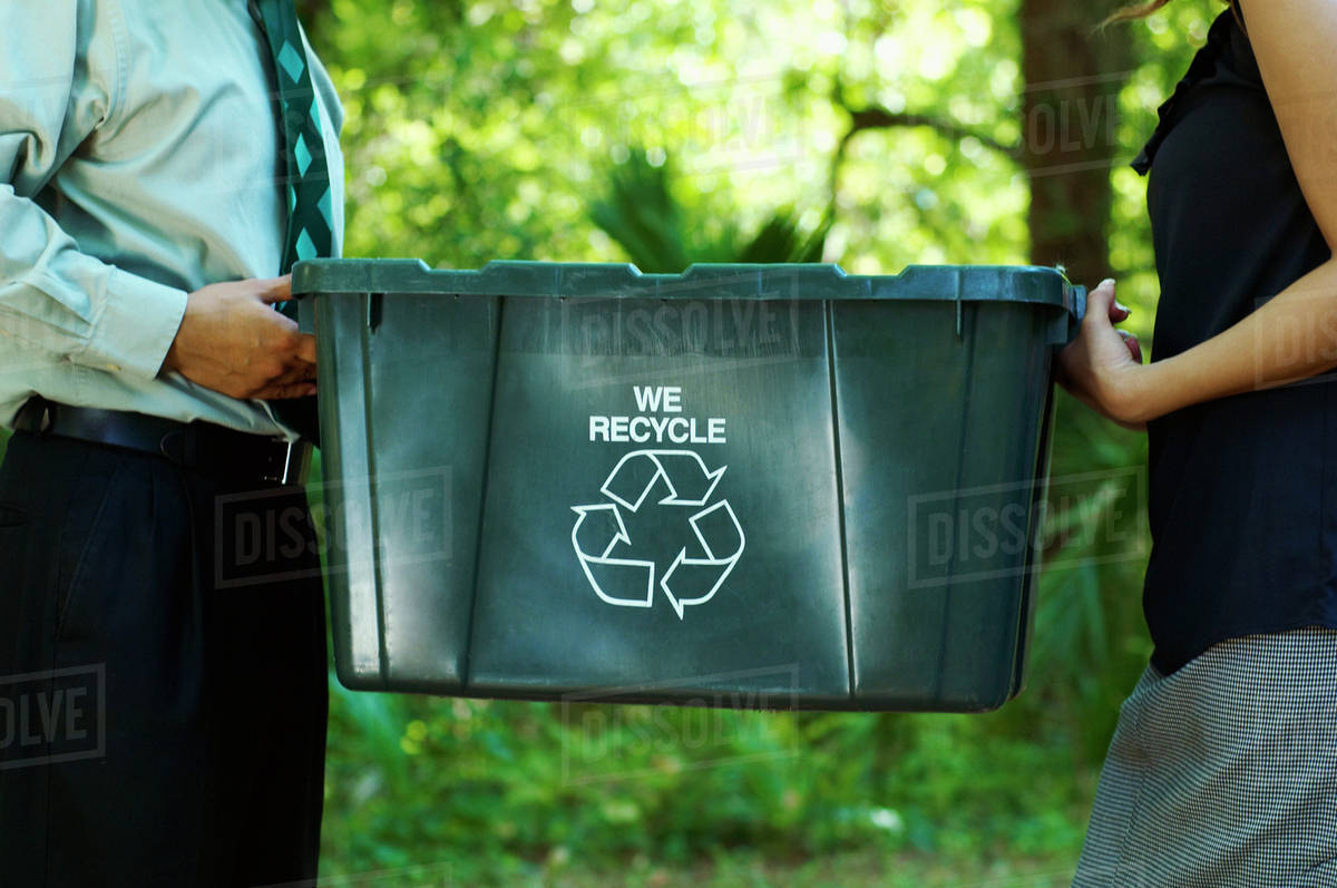 Hispanic business people carrying recycling bin - Stock Photo - Dissolve