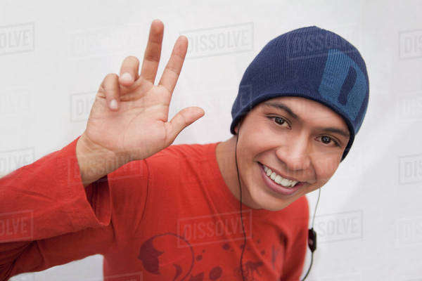 Hispanic man in cap listening to headphones and waving - Royalty-free ...
