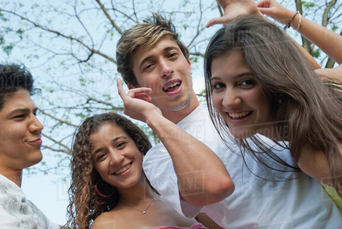 Playful Hispanic friends smiling - Stock Photo - Dissolve
