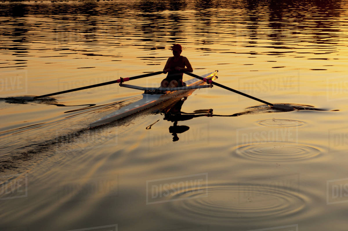 Person rowing sculling boat on river - Stock Photo - Dissolve
