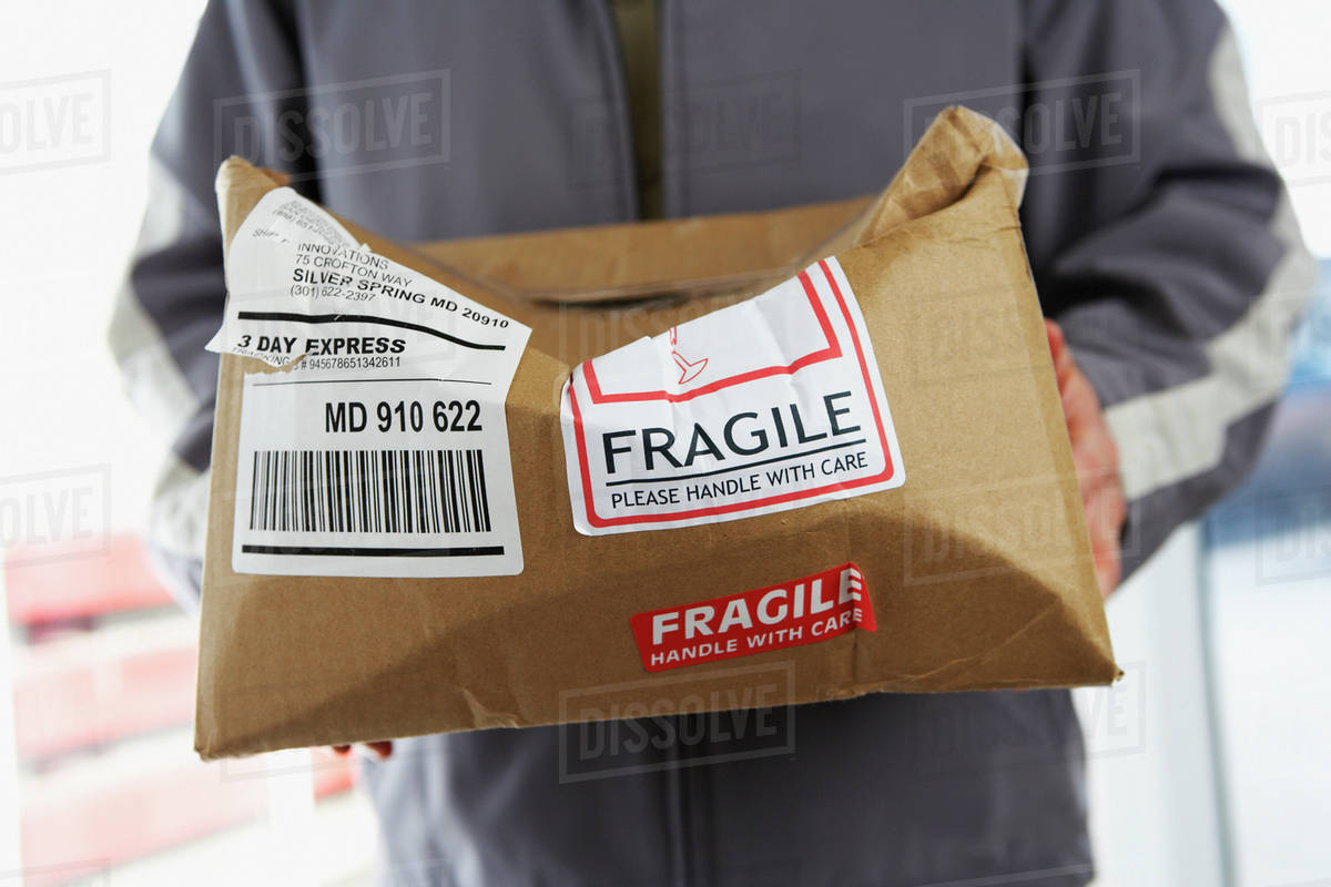 Man holding crushed package marked Fragile - Royalty-free Stock Photo ...