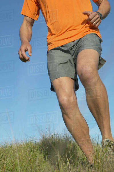 Man walking through grass - Stock Photo - Dissolve
