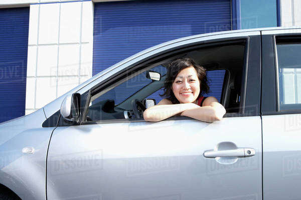 Portrait of Asian woman leaning out car window - Stock Photo - Dissolve