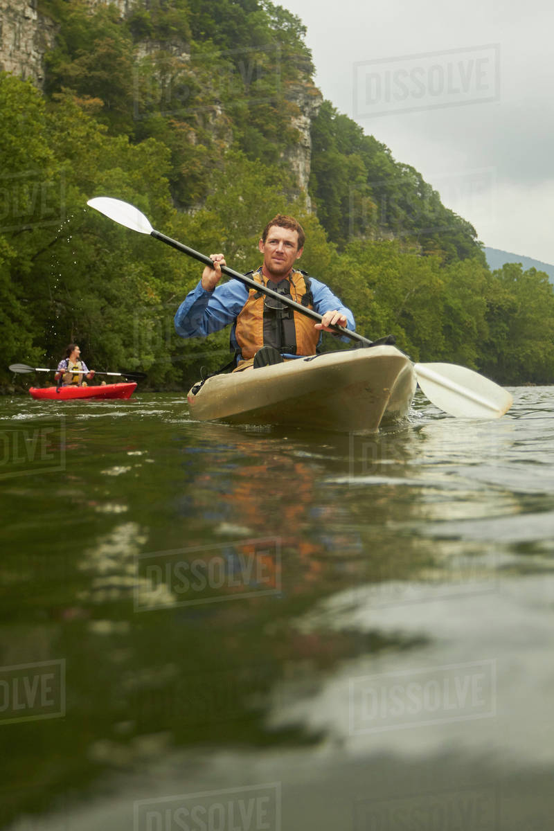Caucasian man paddling kayak on remote river - Royalty-free Stock Photo ...