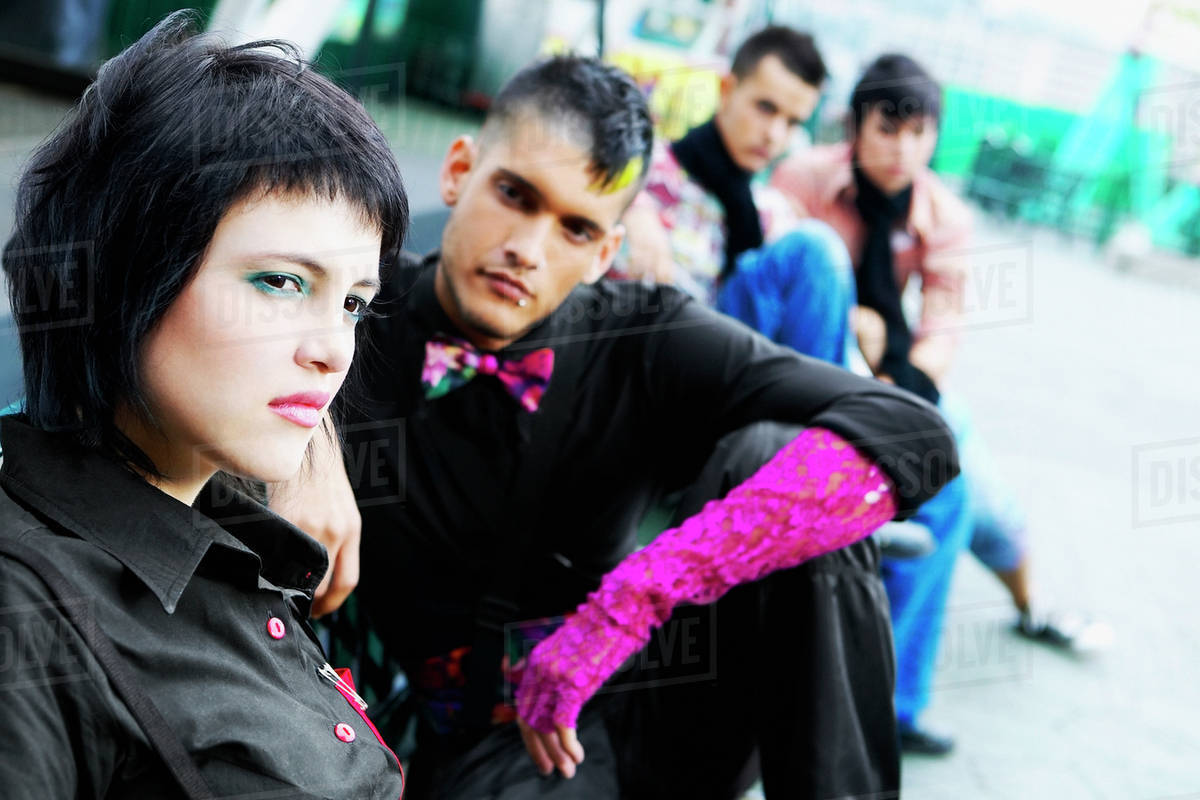 Group of punk Hispanic teenagers sitting on urban sidewalk - Stock ...