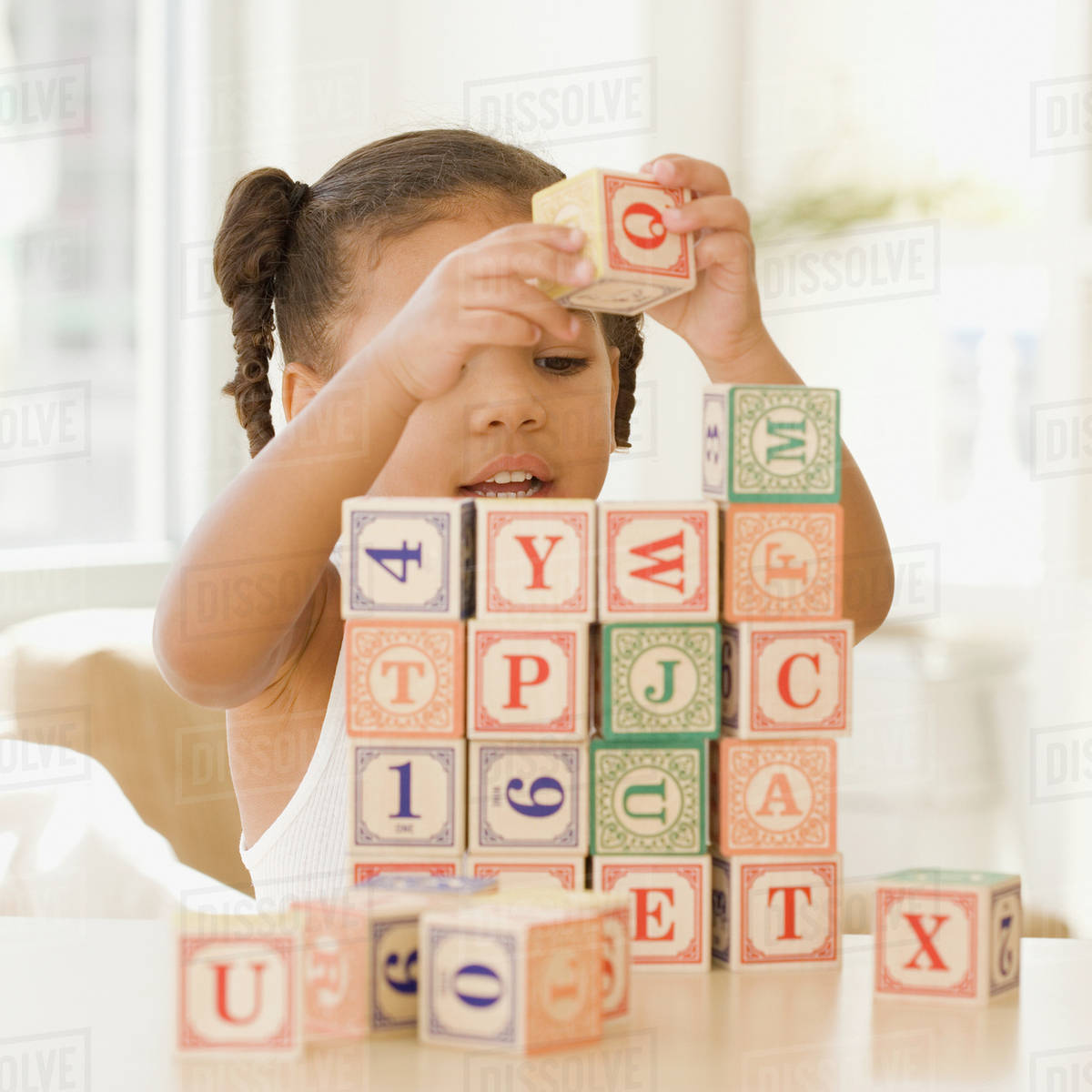 African girl building wall of blocks - Royalty-free Stock Photo | Dissolve