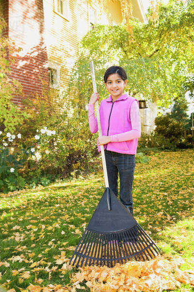 Hispanic girl raking leaves - Royalty-free Stock Photo | Dissolve