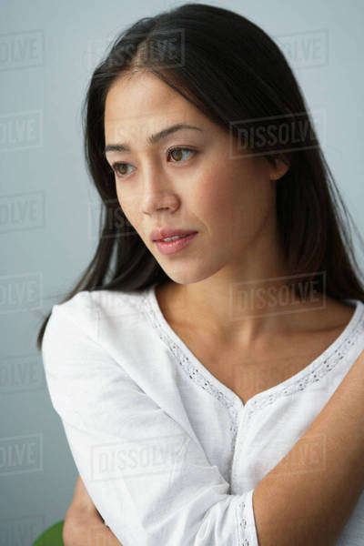 Asian woman holding arm across chest - Royalty-free Stock Photo | Dissolve