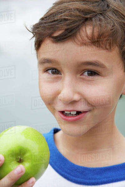 Boy holding apple - Stock Photo - Dissolve