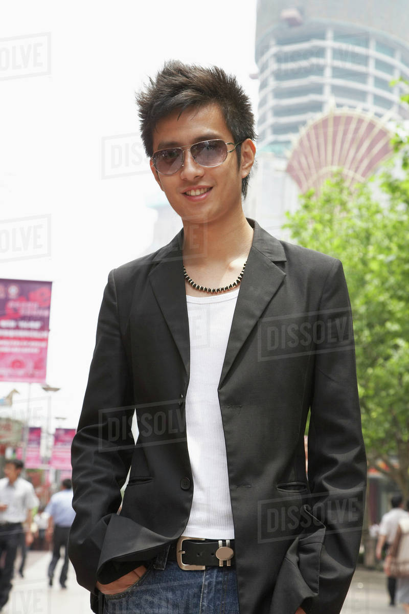 Smiling Chinese man standing outdoors - Royalty-free Stock Photo | Dissolve