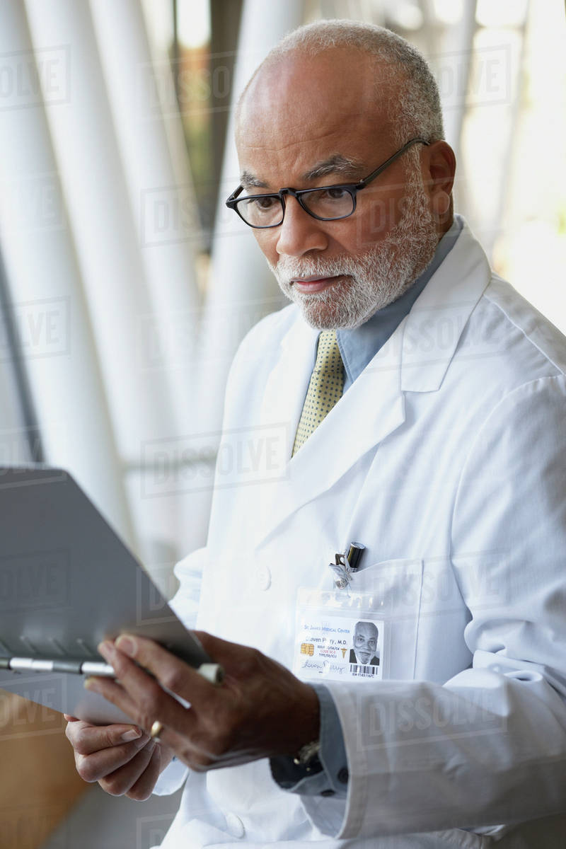 Senior male African doctor reading chart - Royalty-free Stock Photo ...