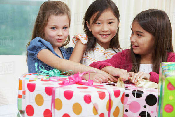 Group of young girls opening gifts - Stock Photo - Dissolve