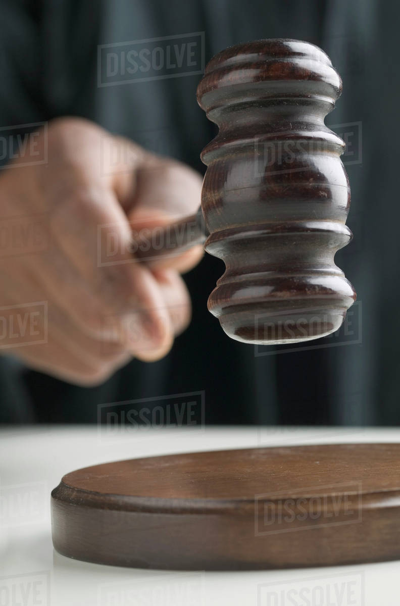 Close up of hand pounding gavel - Royalty-free Stock Photo | Dissolve