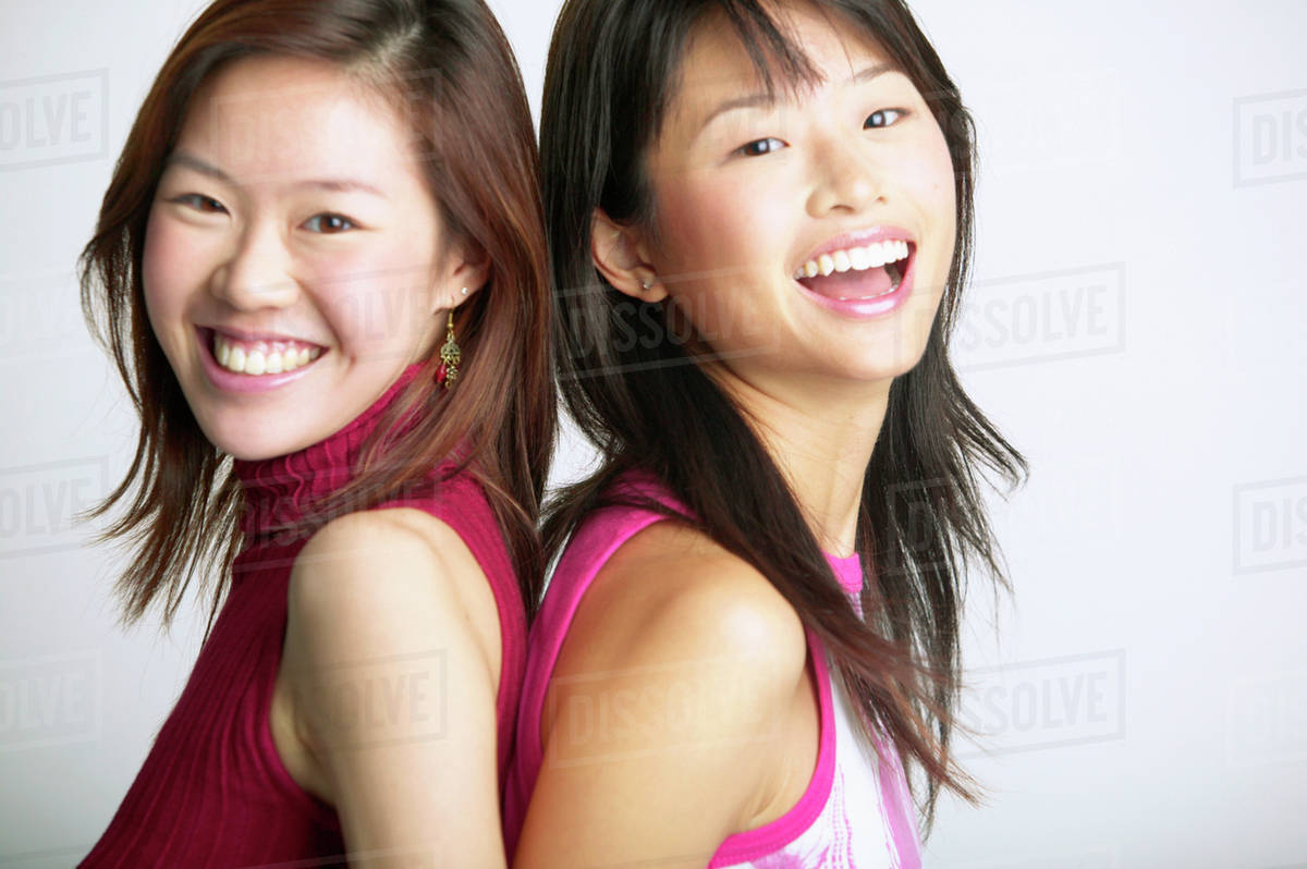 Portrait of sisters back to back - Royalty-free Stock Photo | Dissolve