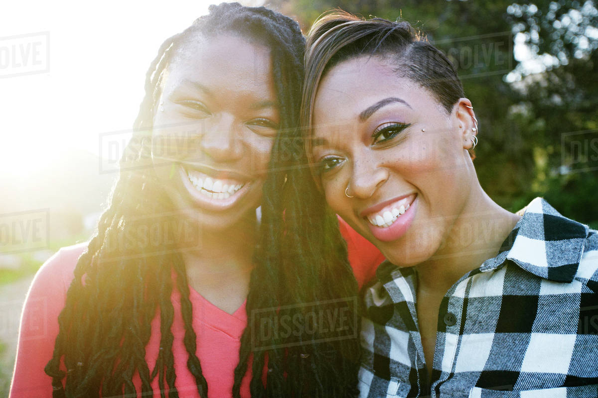Smiling women hugging outdoors - Stock Photo - Dissolve