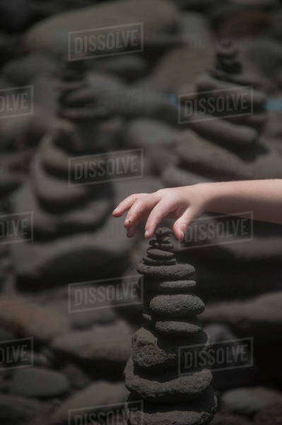 Close up of hand stacking rocks - Stock Photo - Dissolve