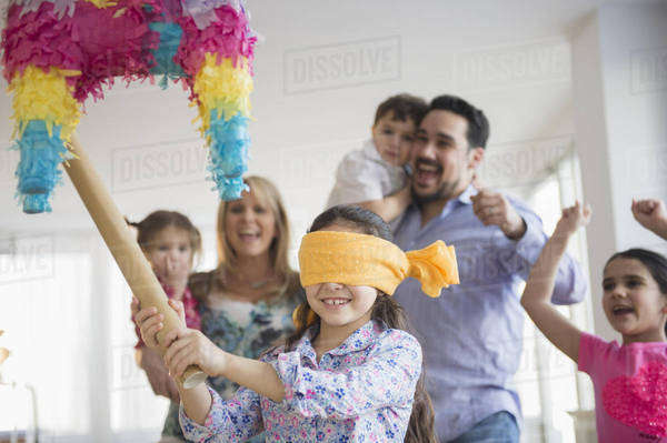 Caucasian girl hitting pinata at birthday party - Stock Photo - Dissolve
