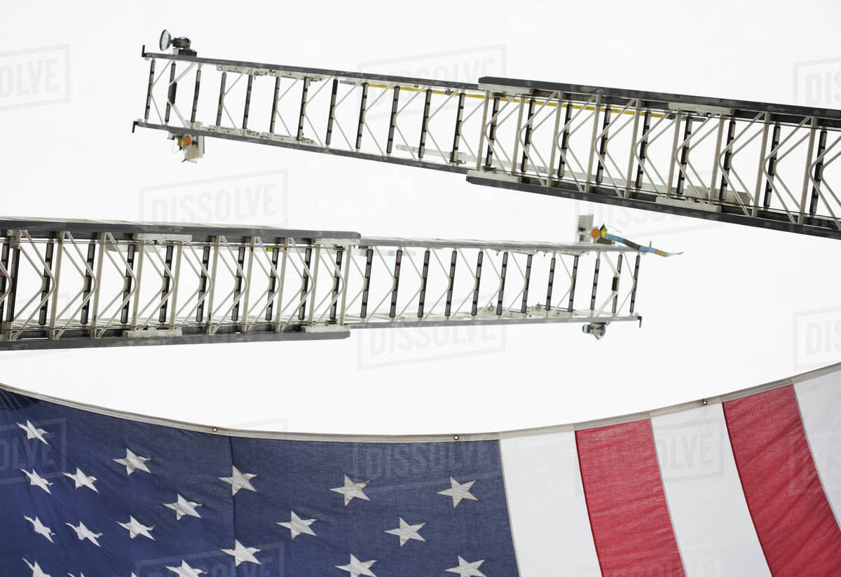 Low angle view of crane ladders and American flag - Royalty-free Stock ...
