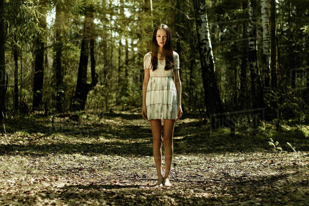 Barefoot Caucasian woman standing in forest - Stock Photo - Dissolve
