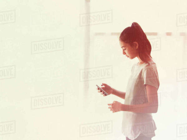 Mixed race girl using cell phone - Royalty-free Stock Photo | Dissolve
